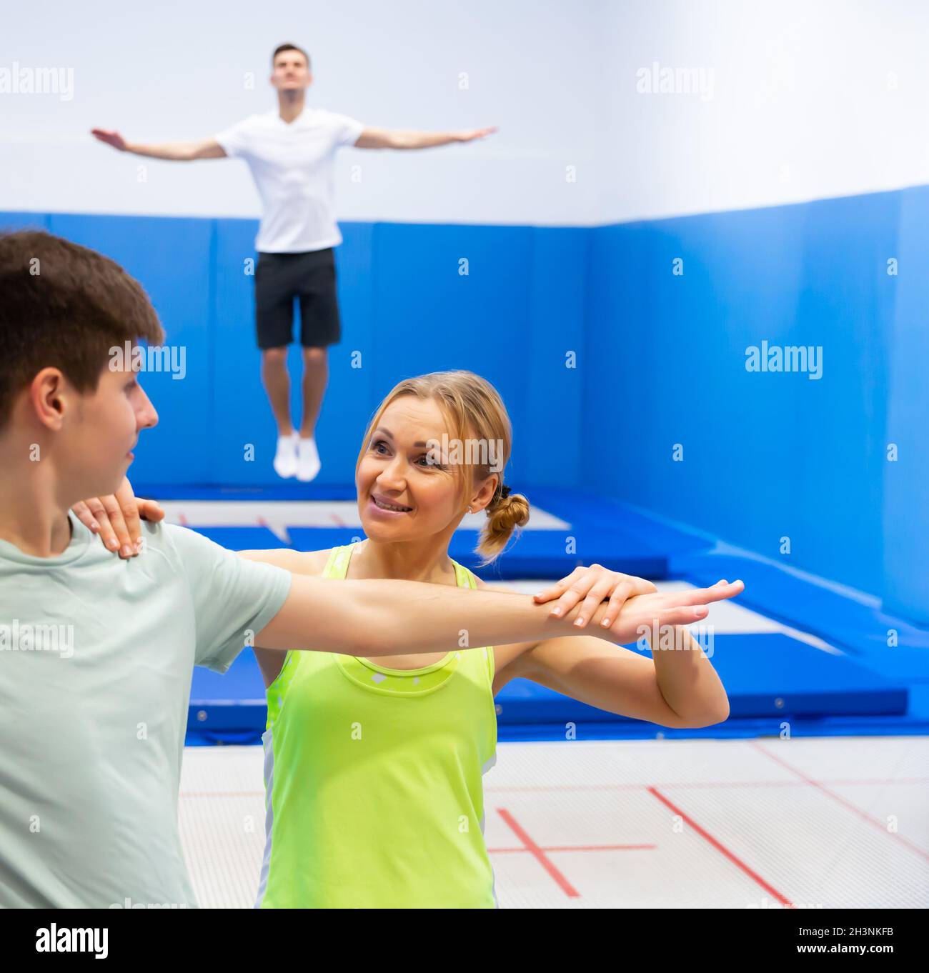 Female coach holding training with teenager in trampoline room Stock ...