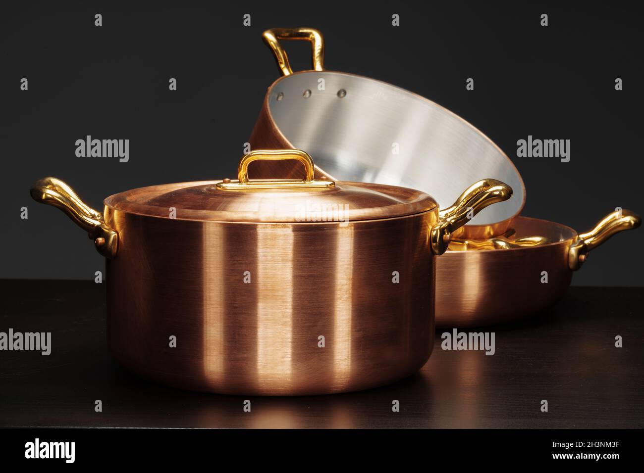 Set of copper cookware over dark background Stock Photo - Alamy