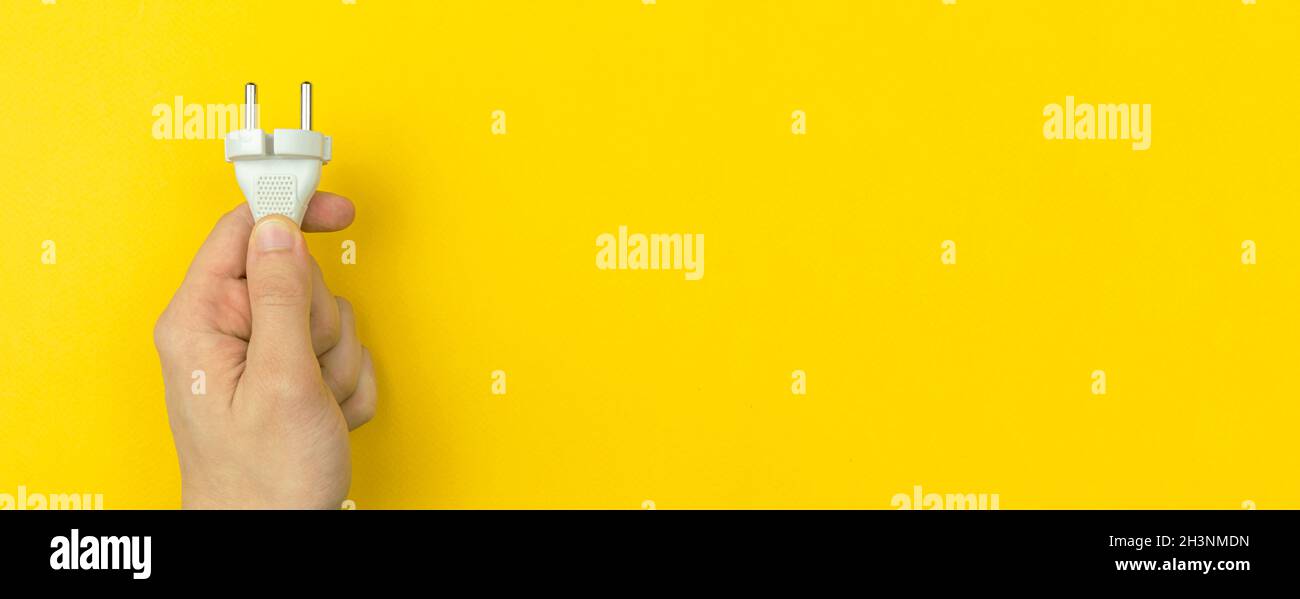 Hand with electrical power cable, banner. Yellow background, flat lay ...