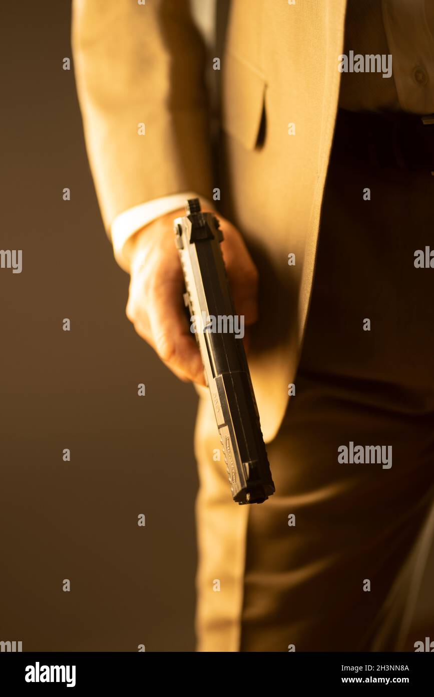 Male detective spy killer holding pistol gun in dramatic novel book ...