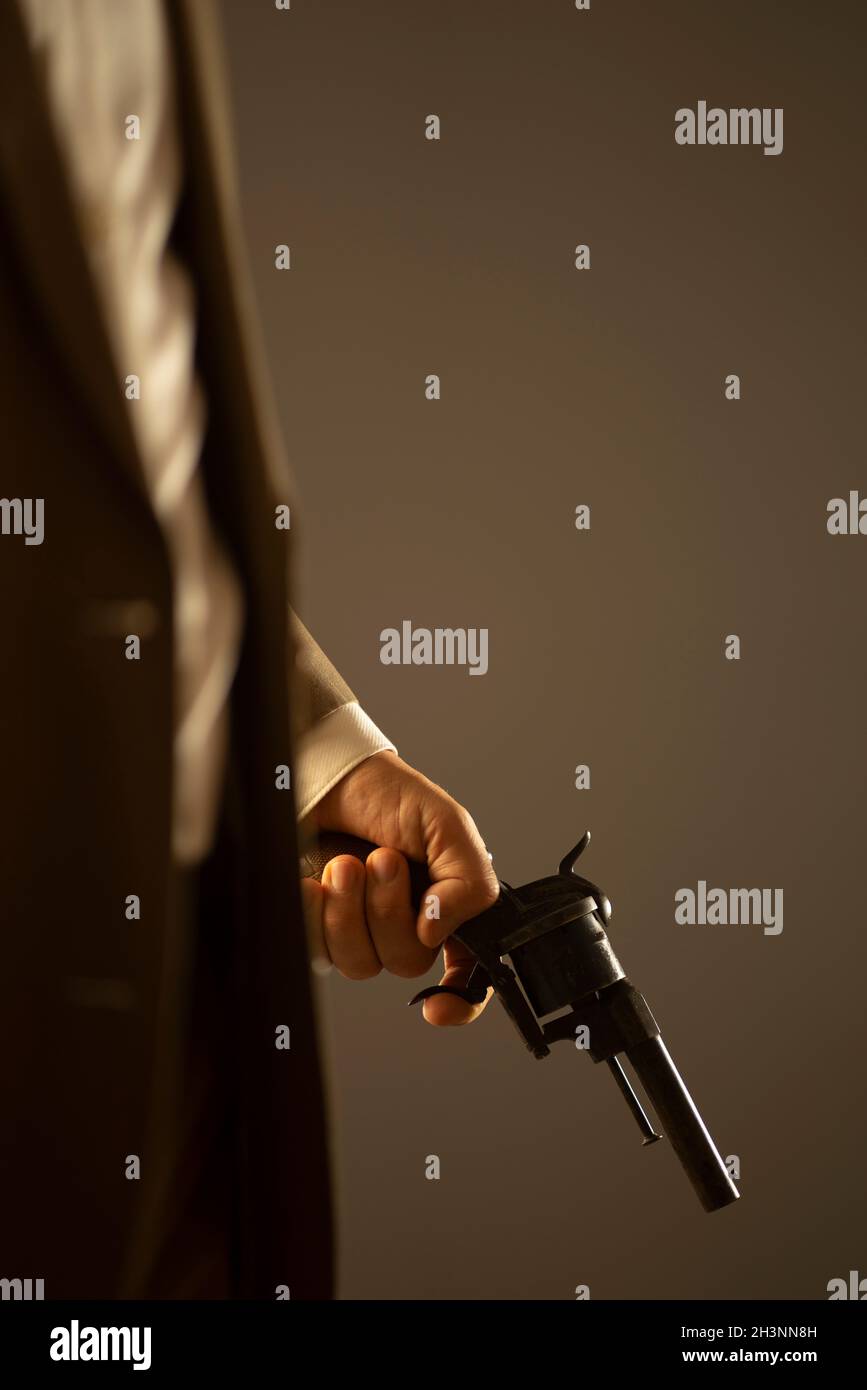 Male detective spy killer holding pistol gun in dramatic novel book ...