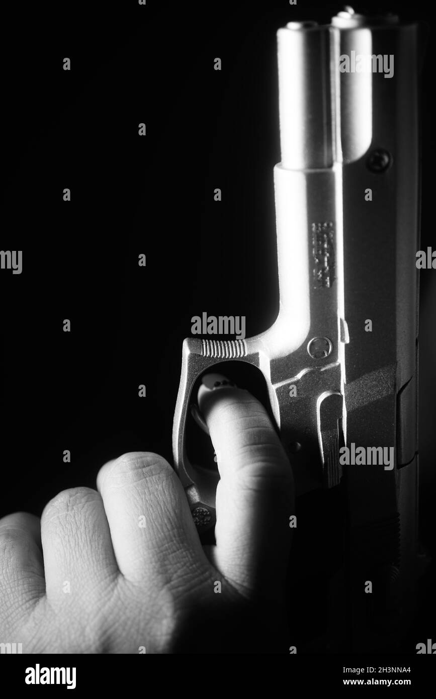 Lady spy detective with painted red nail varnish holding pistol gun at ...