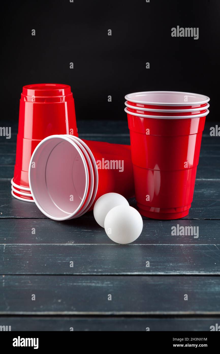 Wooden table with red cups and ball for beer pong Stock Photo - Alamy