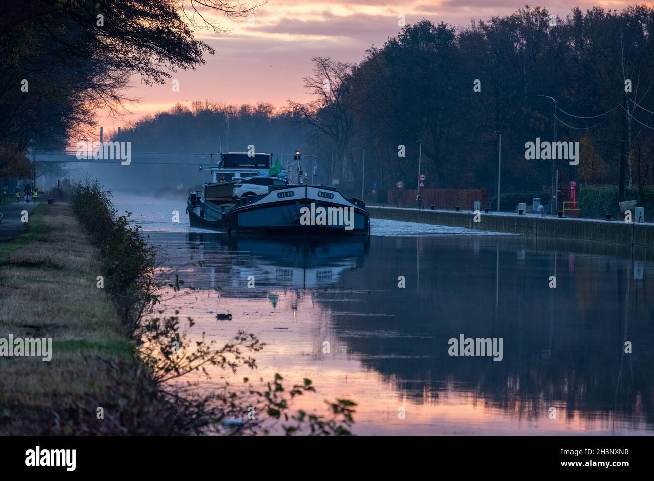 Cargo ship on a river during a misty sunrise morning Stock Photo - Alamy