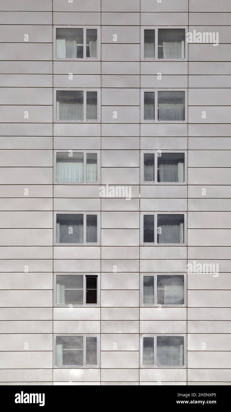Close up of a grey modern concrete highrise building with geometrical ...