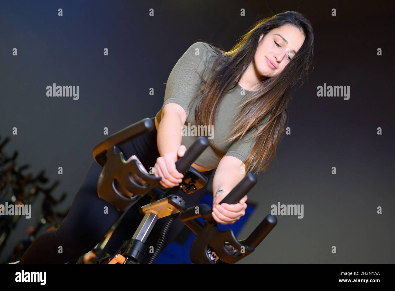 Woman in gym spinning on fitness bike Stock Photo - Alamy
