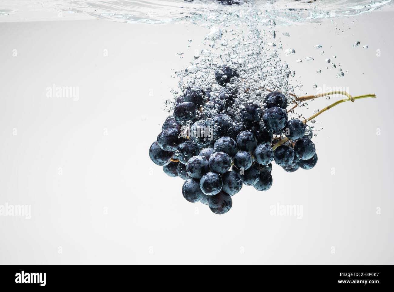 Bunch of blue grapes sinking underwater with splash Stock Photo - Alamy