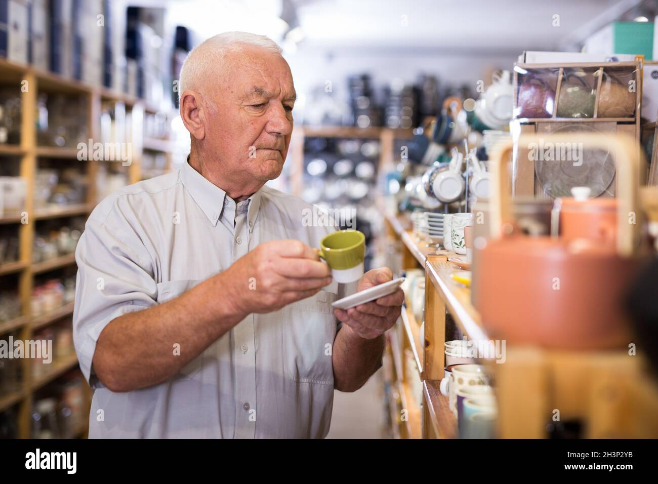 Mature man choosing new dishes at store Stock Photo - Alamy