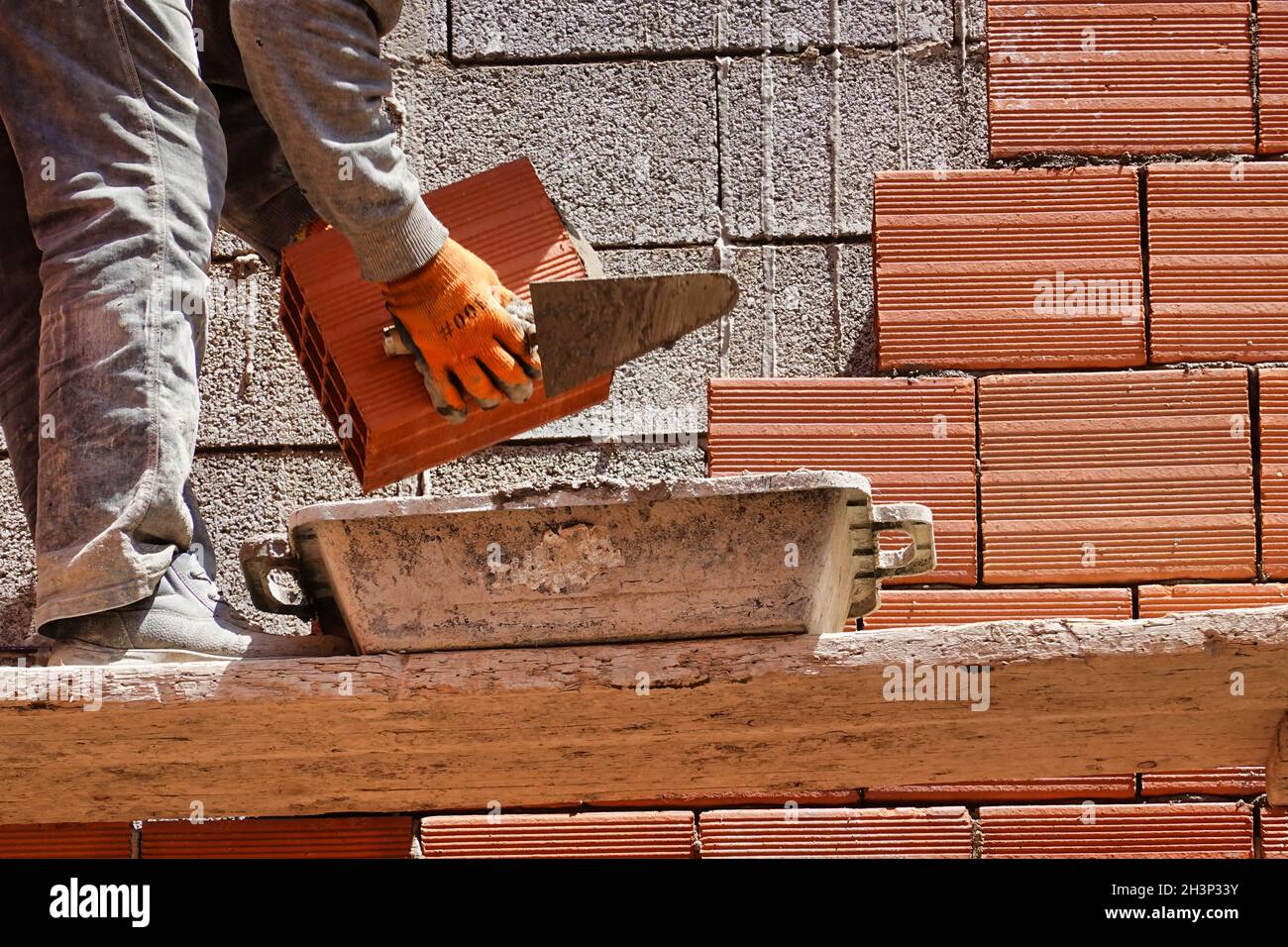 Worker constructing a brick wall in an industrial area Stock Photo - Alamy