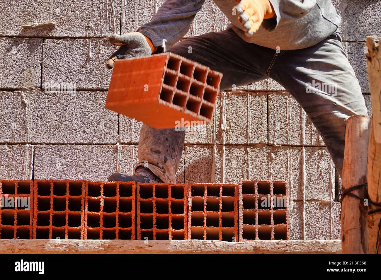 Worker constructing a brick wall in an industrial area Stock Photo - Alamy