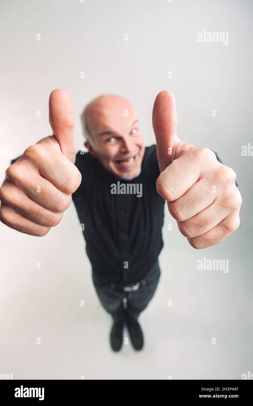 Excited exuberant man giving a double thumbs up gesture conceptual of ...
