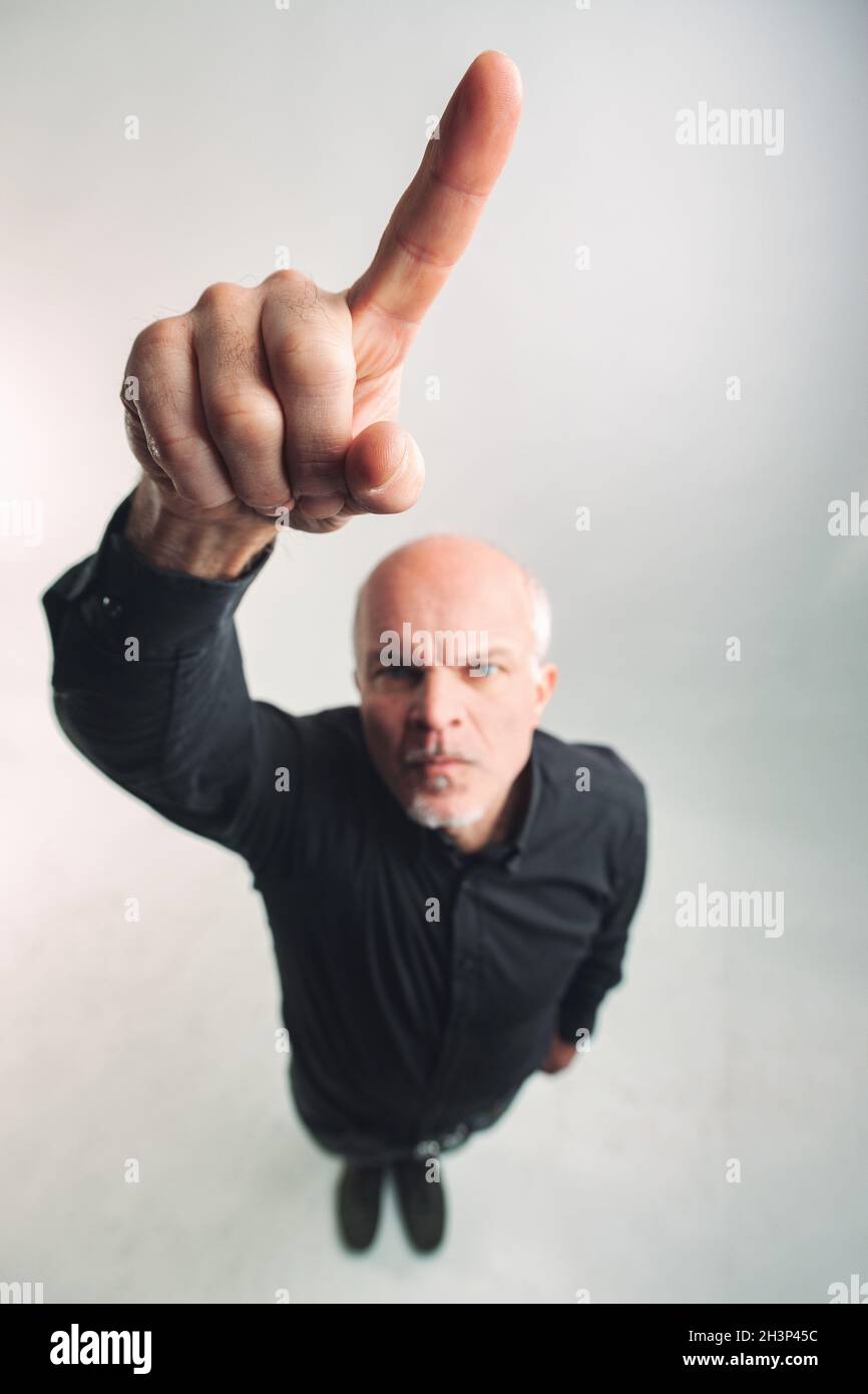 Top down perspective of an senior angry man frowning and pointing a ...