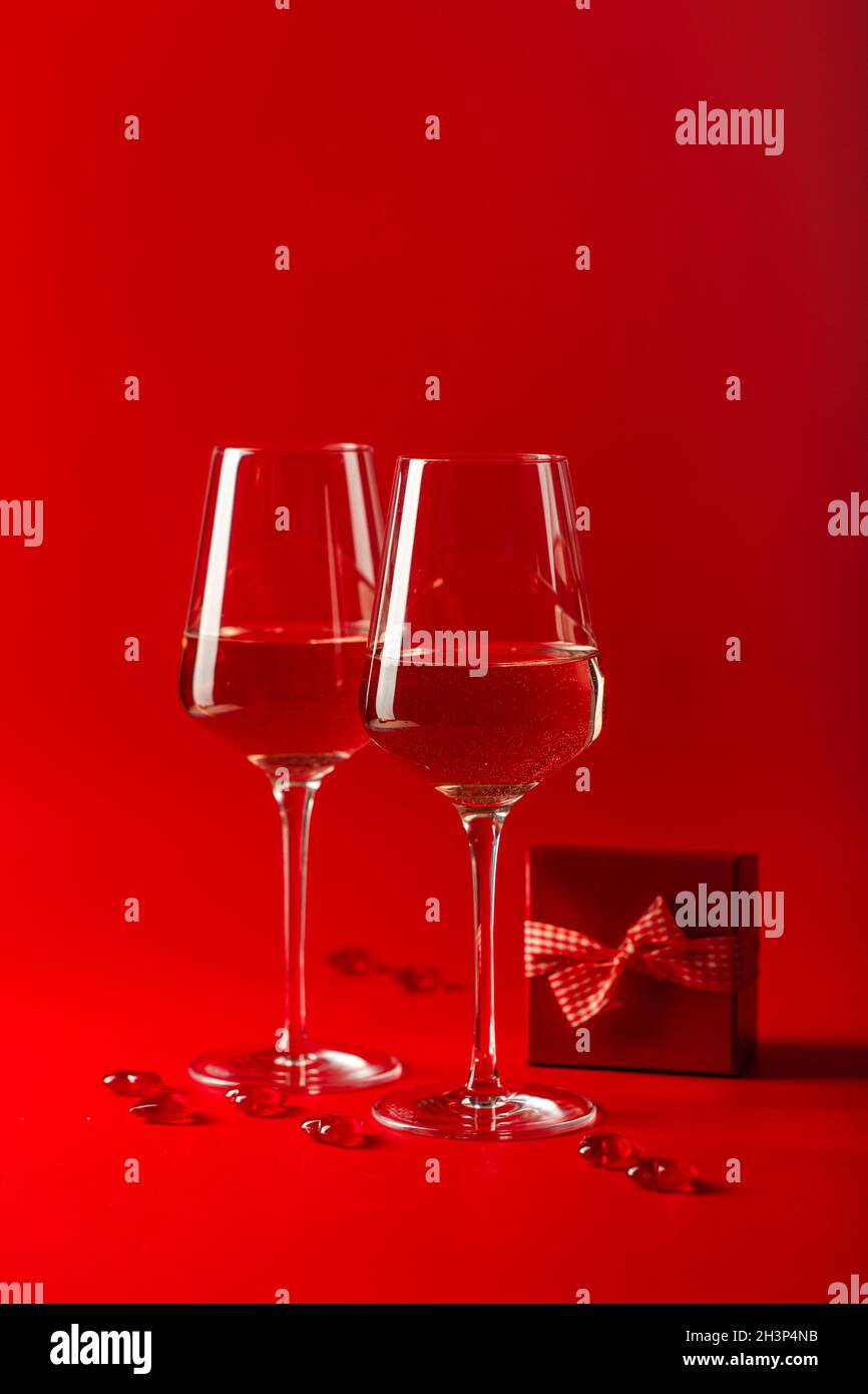 Two full glasses of wine over red background Stock Photo - Alamy