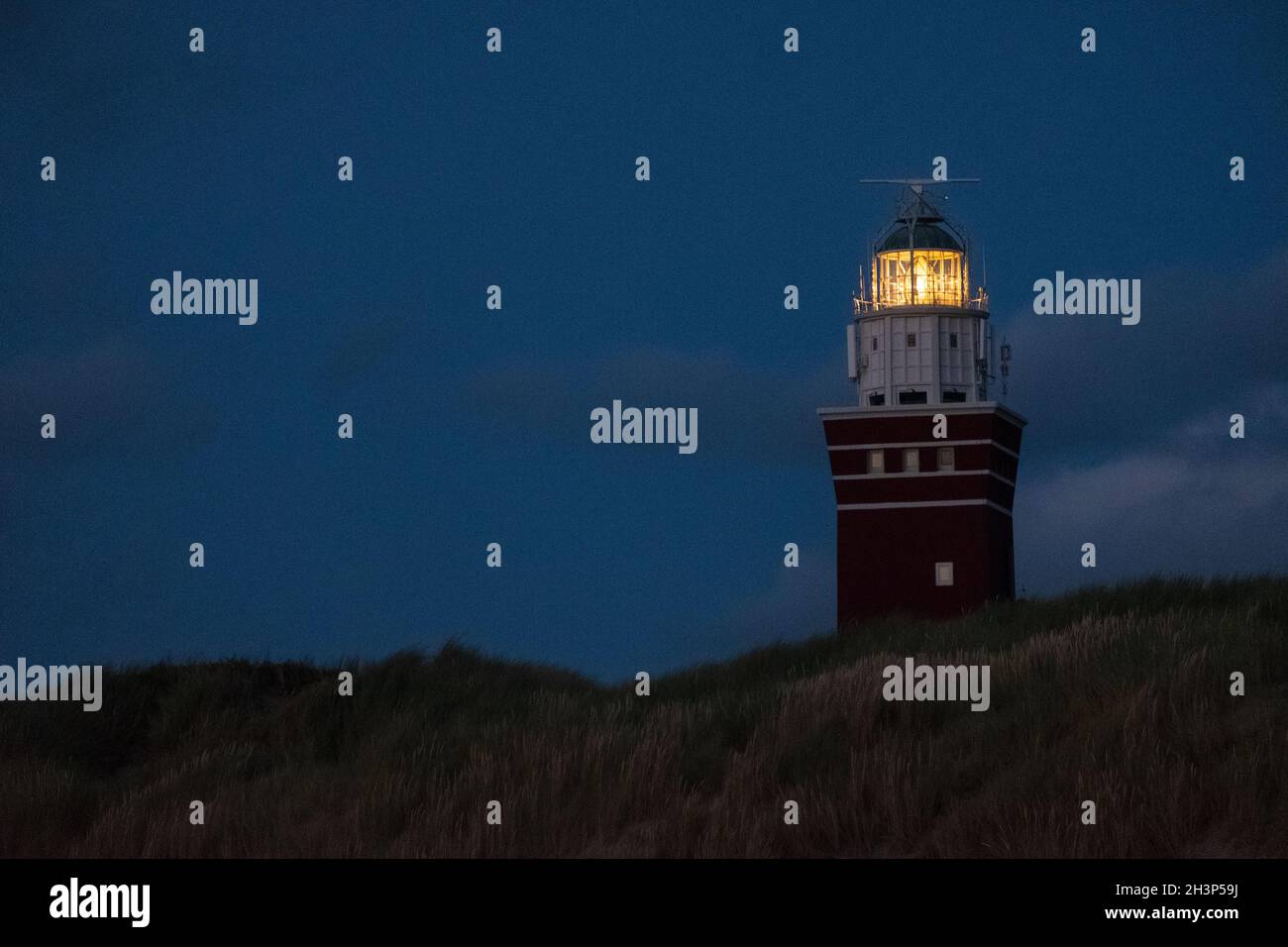 Lighthouse standing on the Dutch coast with a dramatic. and colorful ...