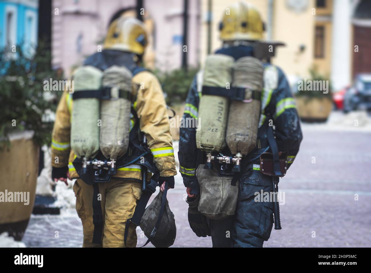 Group of fire men in uniform during fire fighting operation in the city ...