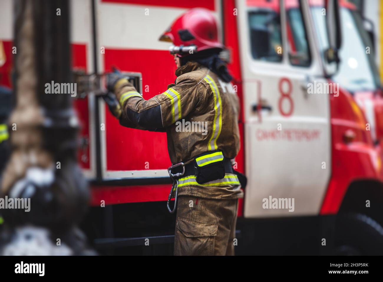Group of fire men in uniform during fire fighting operation in the city ...
