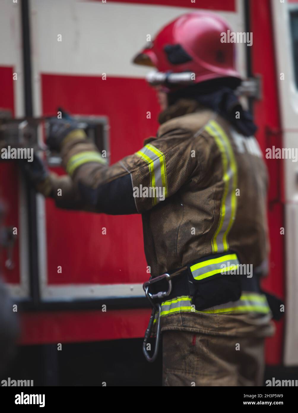 Group of fire men in uniform during fire fighting operation in the city ...