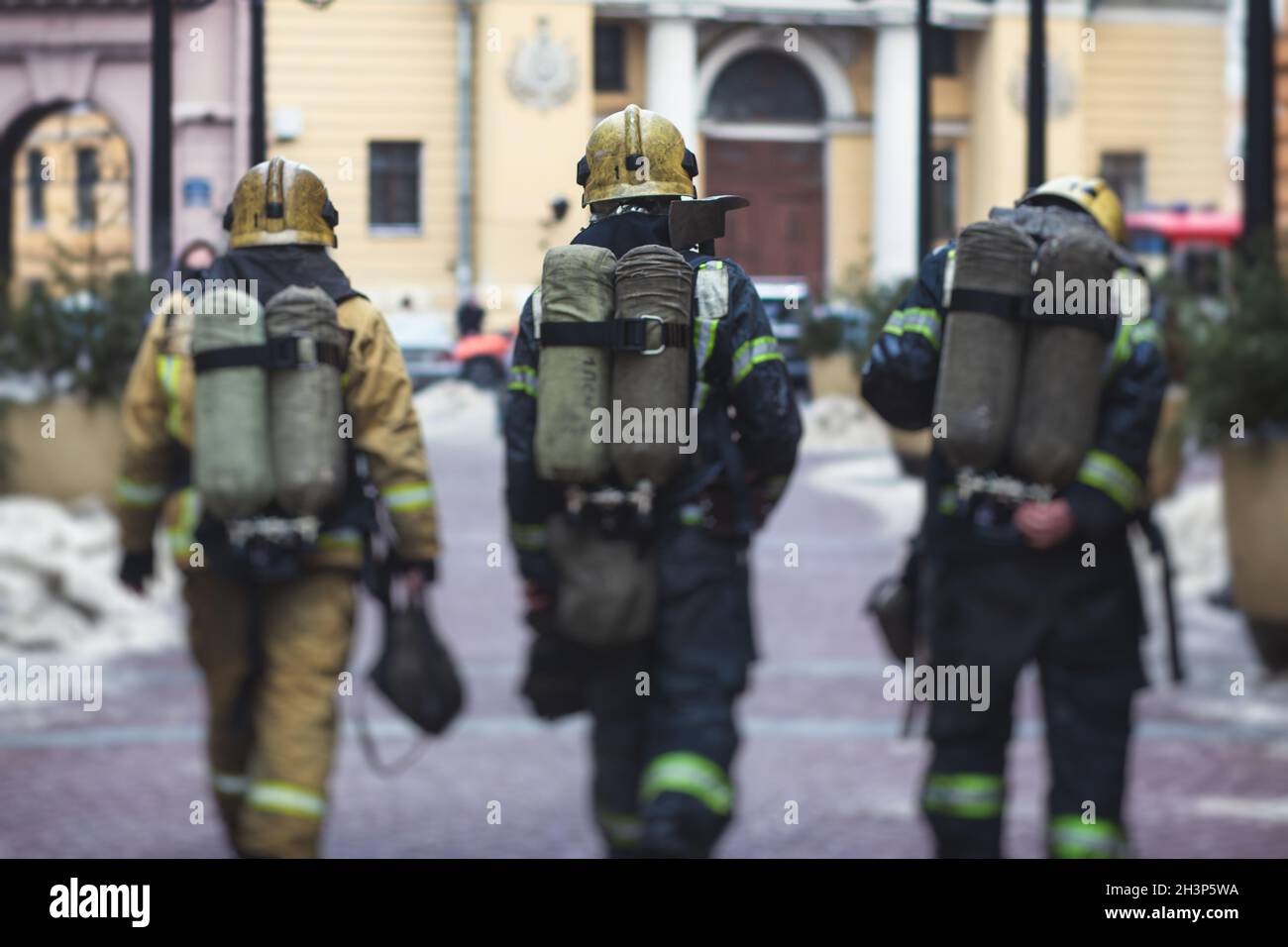 Group of fire men in uniform during fire fighting operation in the city ...