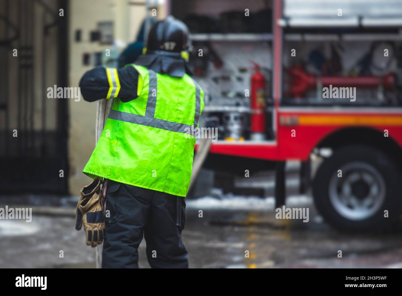 Group of fire men in uniform during fire fighting operation in the city ...