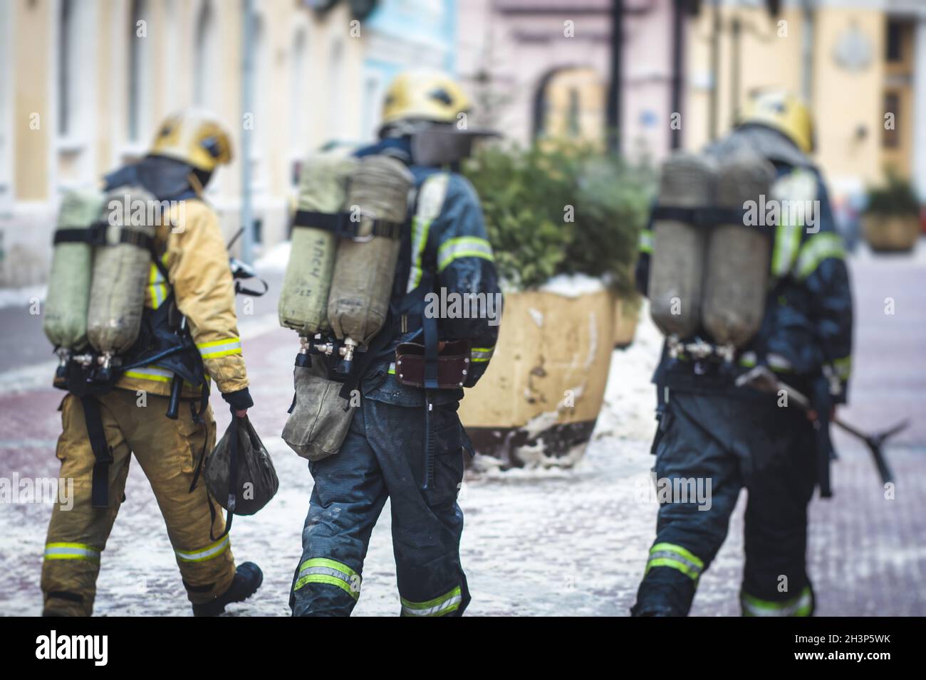 Group of fire men in uniform during fire fighting operation in the city ...