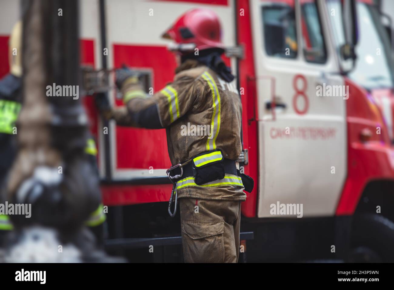 Group of fire men in uniform during fire fighting operation in the city ...