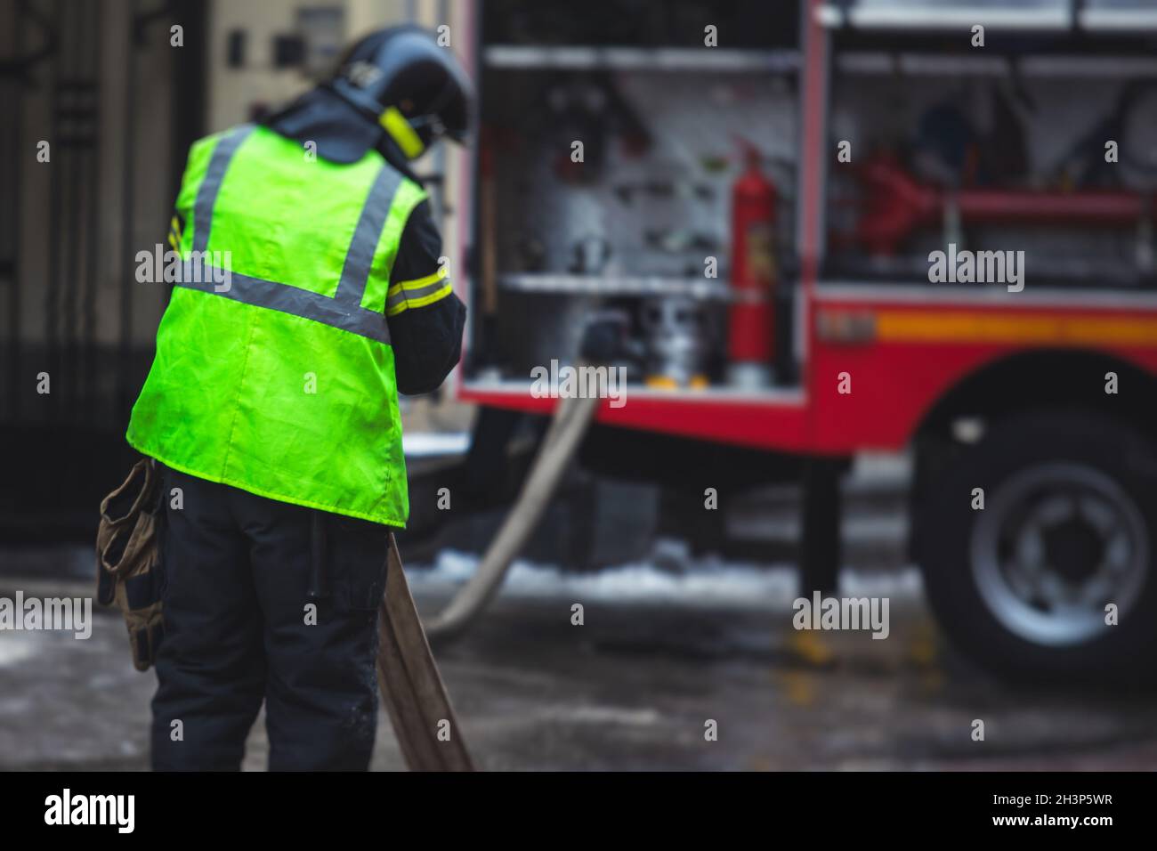Group of fire men in uniform during fire fighting operation in the city ...
