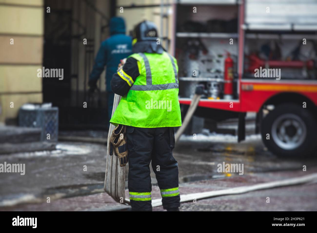 Group of fire men in uniform during fire fighting operation in the city ...