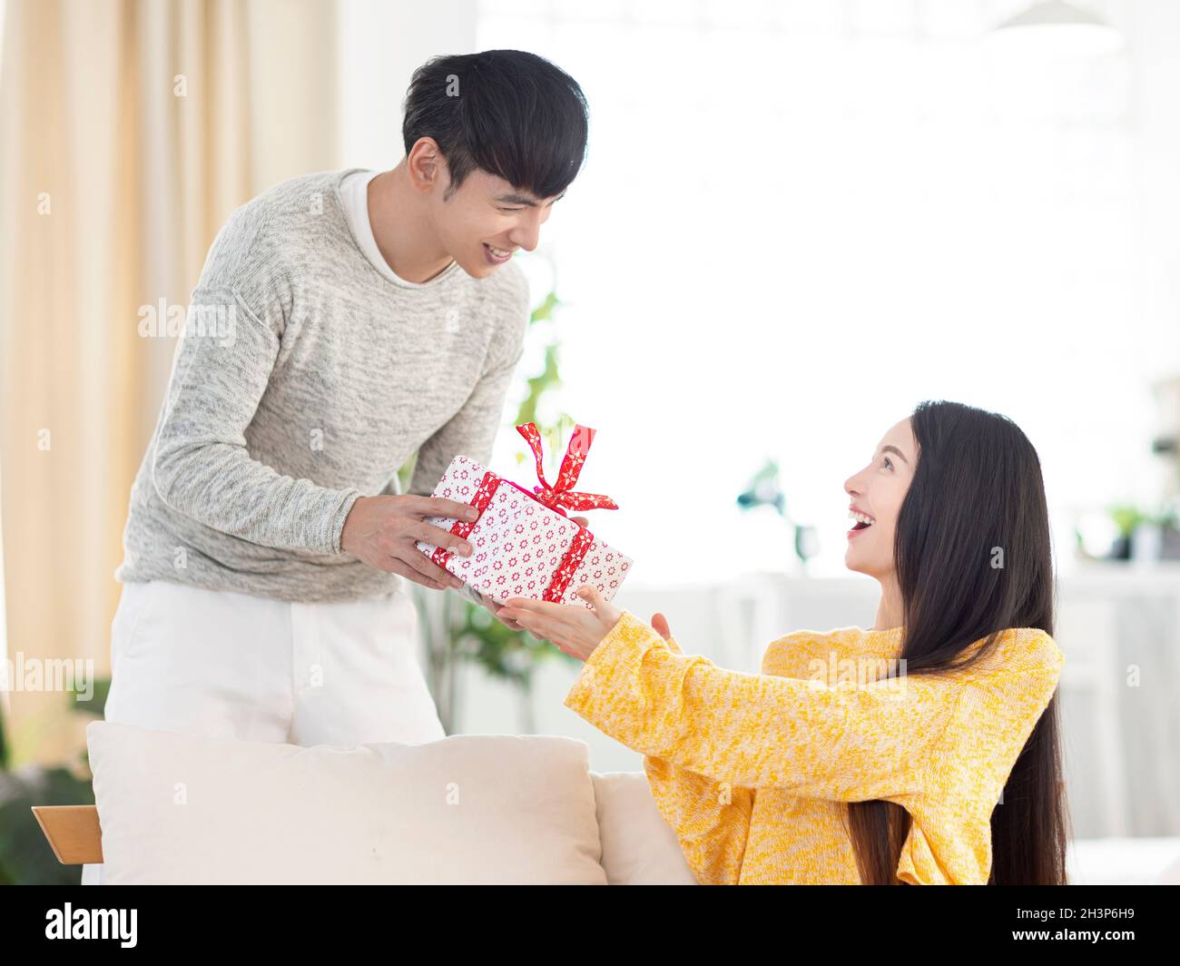 Man gives woman a gift to celebrating holiday Stock Photo - Alamy