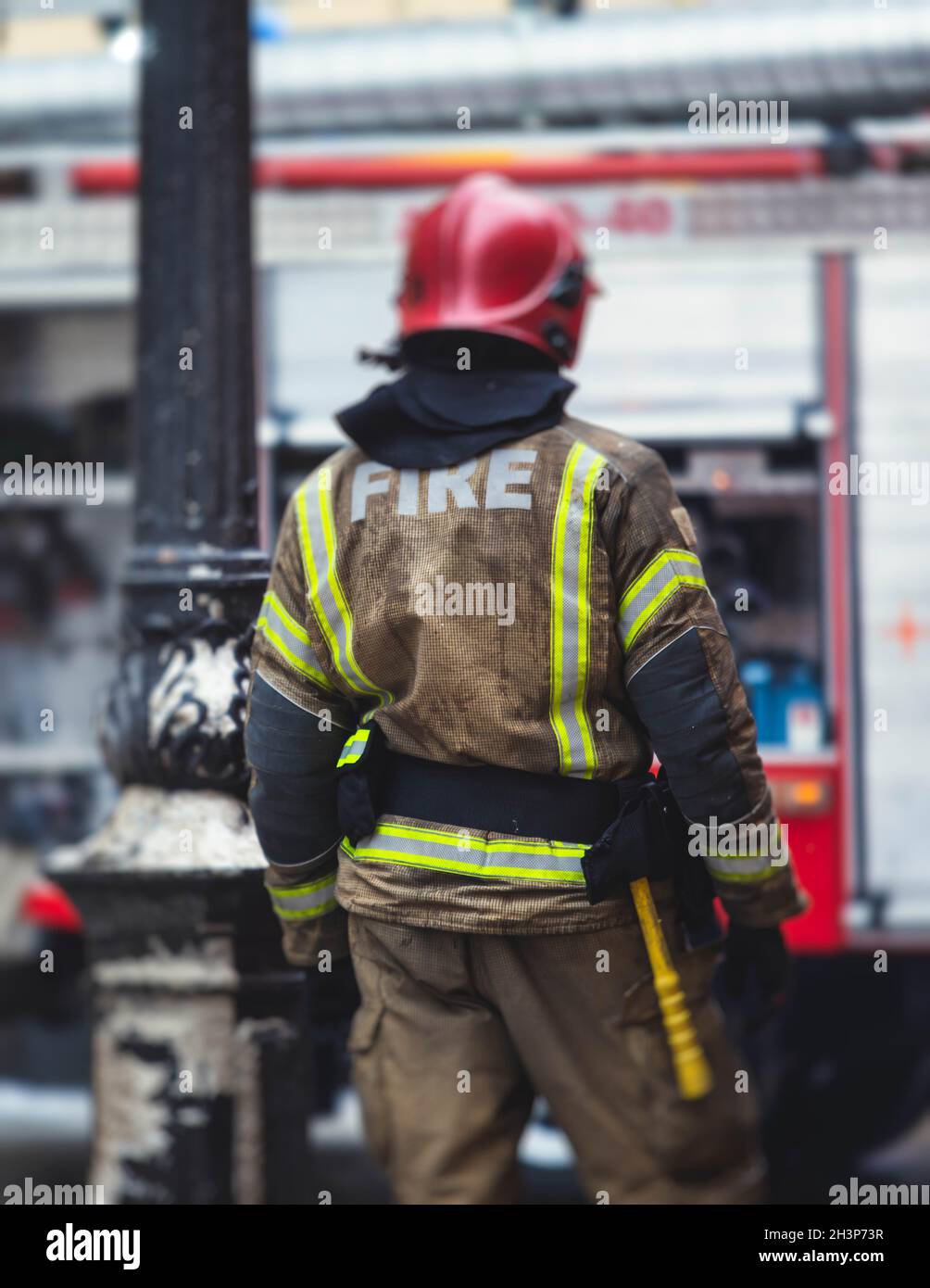 Group of fire men in uniform during fire fighting operation in the city ...
