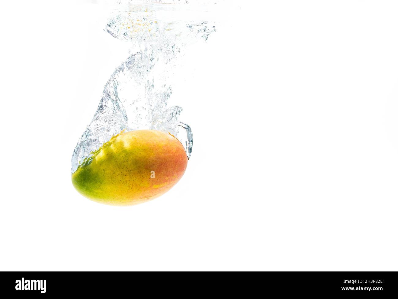 Mango fruit splashing into water, isolated on white Stock Photo - Alamy