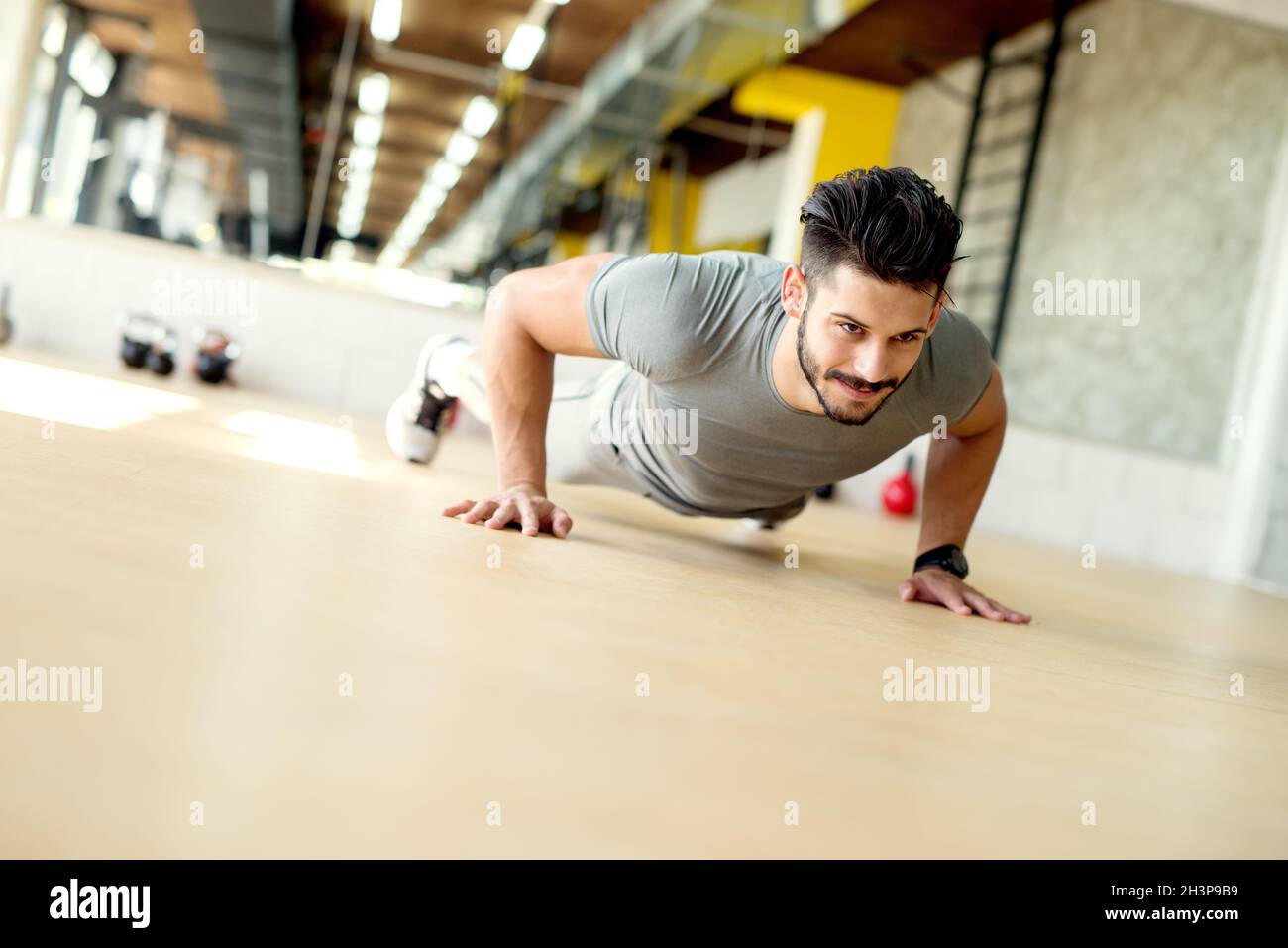 handsome young man doing push ups at the gym. Self motivation ...