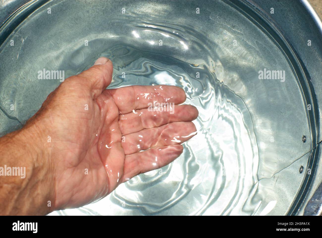 Palm of a hand in a bucket of fresh water Stock Photo - Alamy
