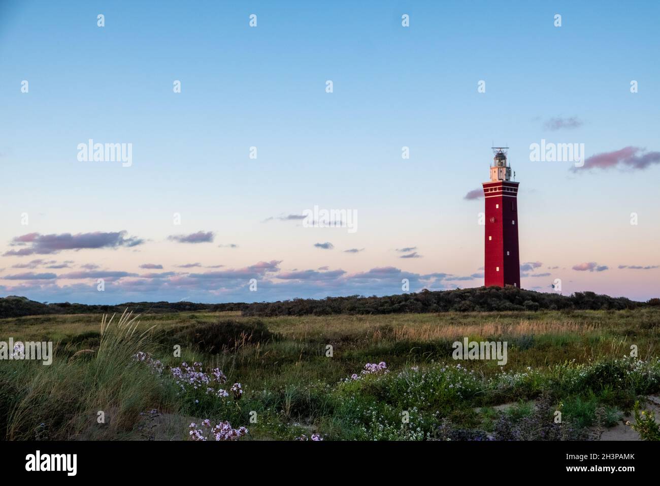 Lighthouse standing on the Dutch coast with a dramatic. and colorful ...