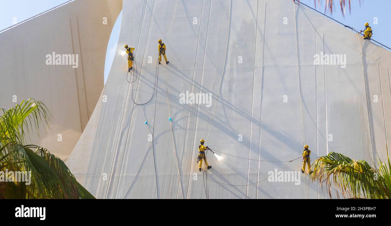 Workers cleaning facade of building with water jet pressure method ...