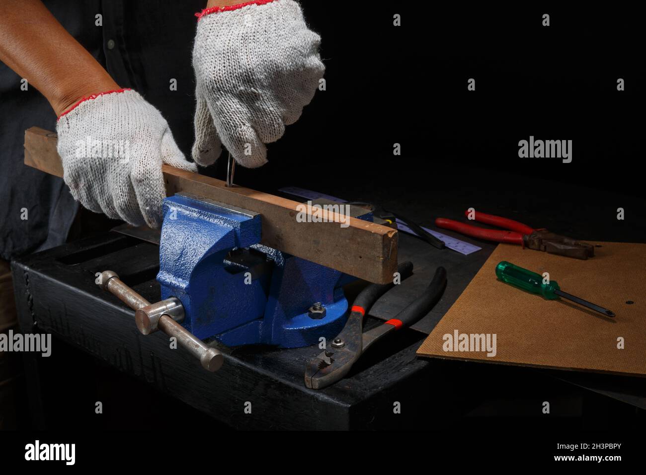 Closeup workers hands on a wooden plank locked in the iron vise Stock ...