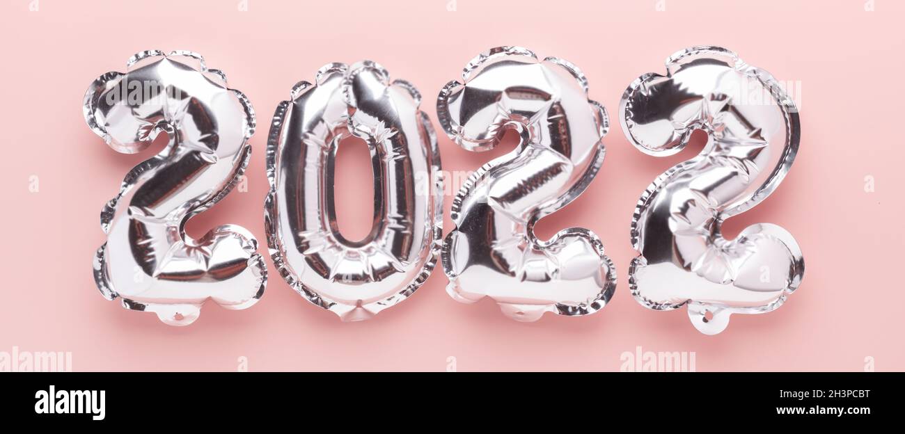 Silver balloons in the form of numbers 2022 on pink background. New ...