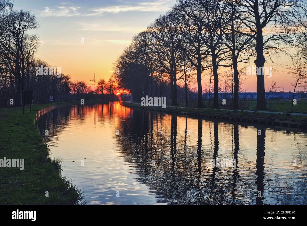 Gold sunset over river with sun rays, tree silhouettes and reflection ...