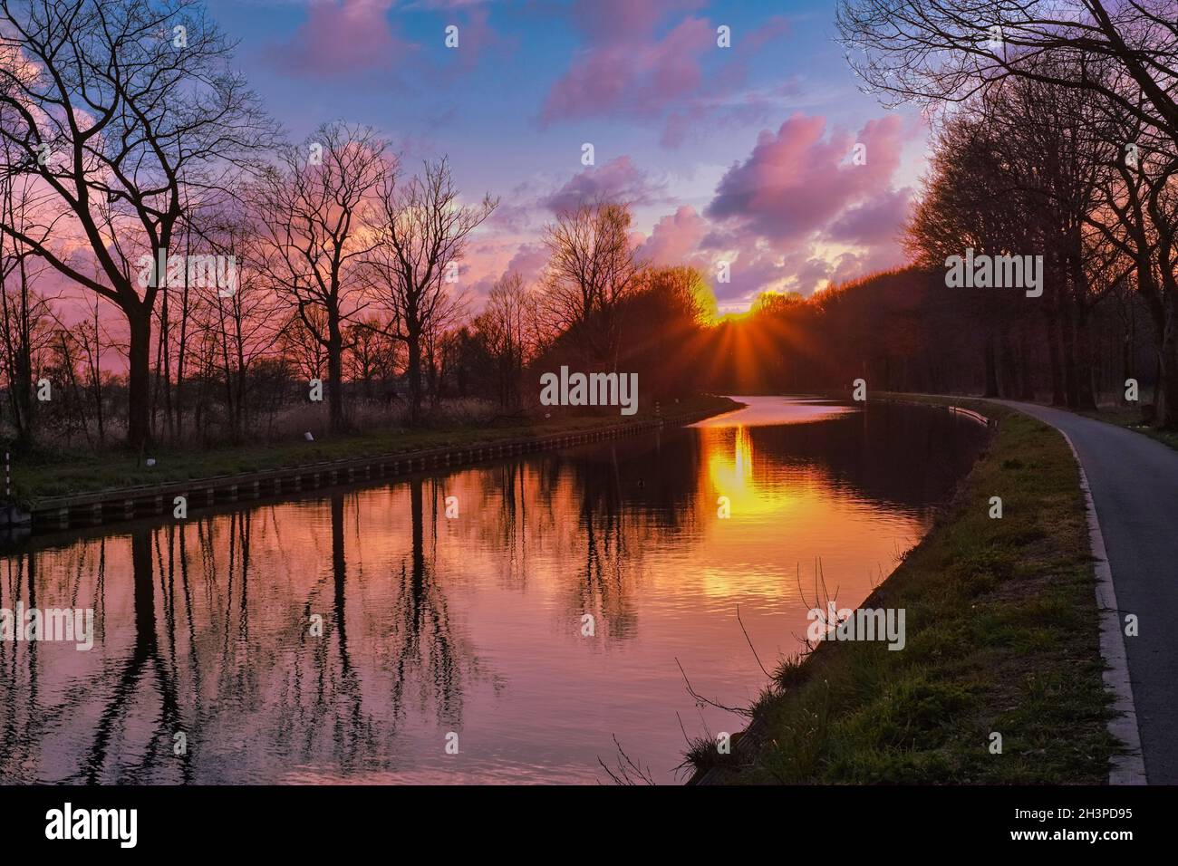 Gold sunset over river with sun rays, tree silhouettes and reflection ...
