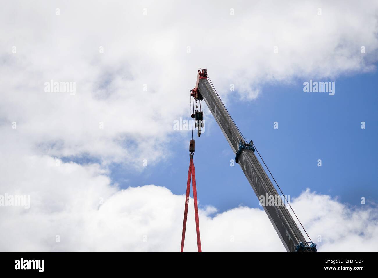 Industrial Crane operating and lifting an construction material in site ...