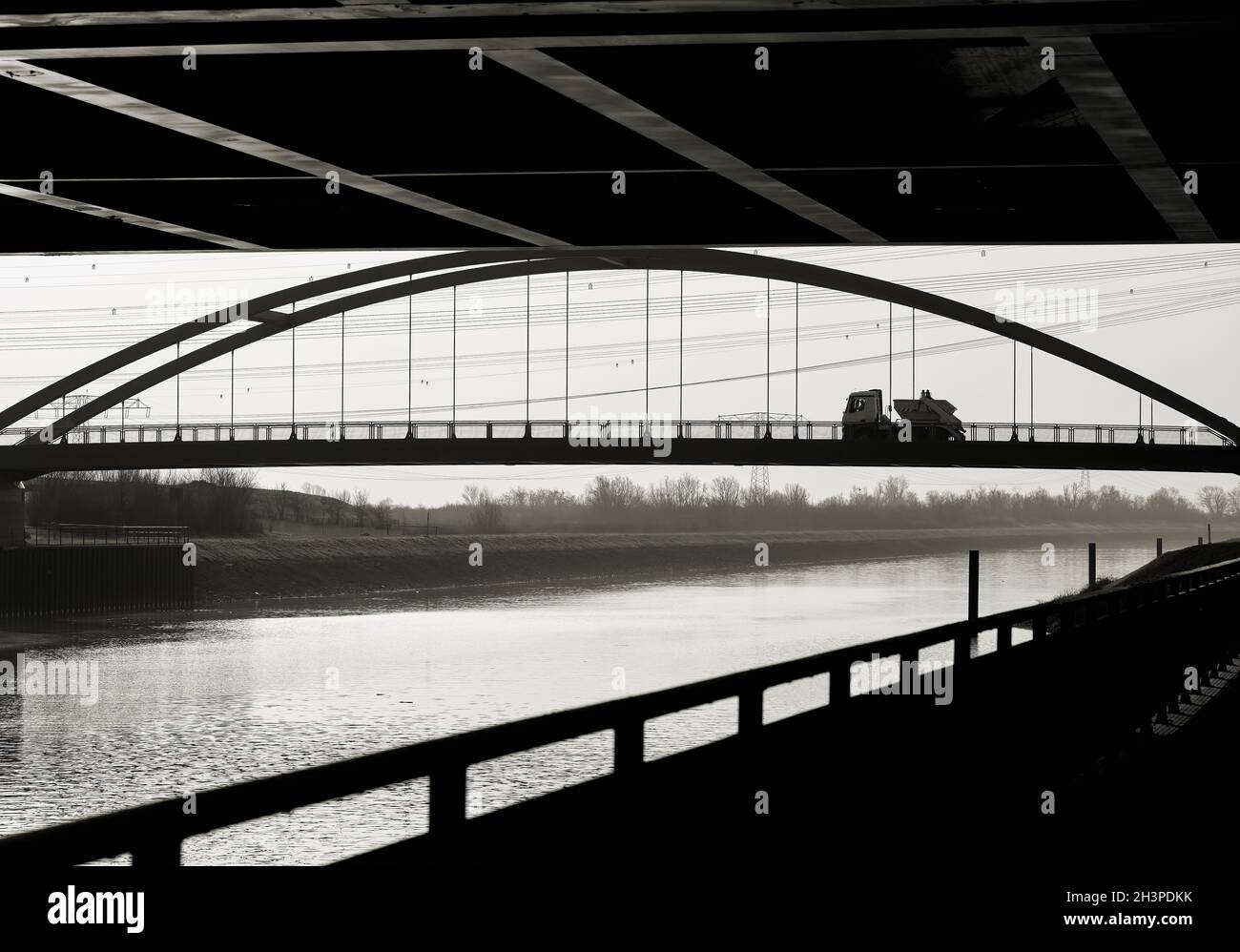 View of an arch bridge from a viewpoint below a highway bridge in ...