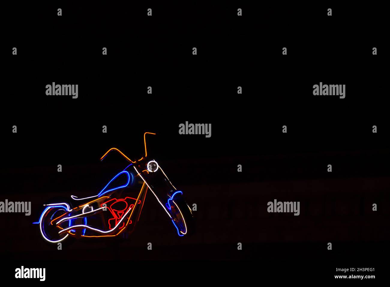 Neon lights design in the shape of a motorbike illuminating the night ...