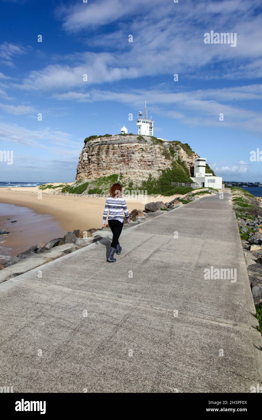 A woman walking along the breakwall at Nobbys Head - Newcastle Harbour ...