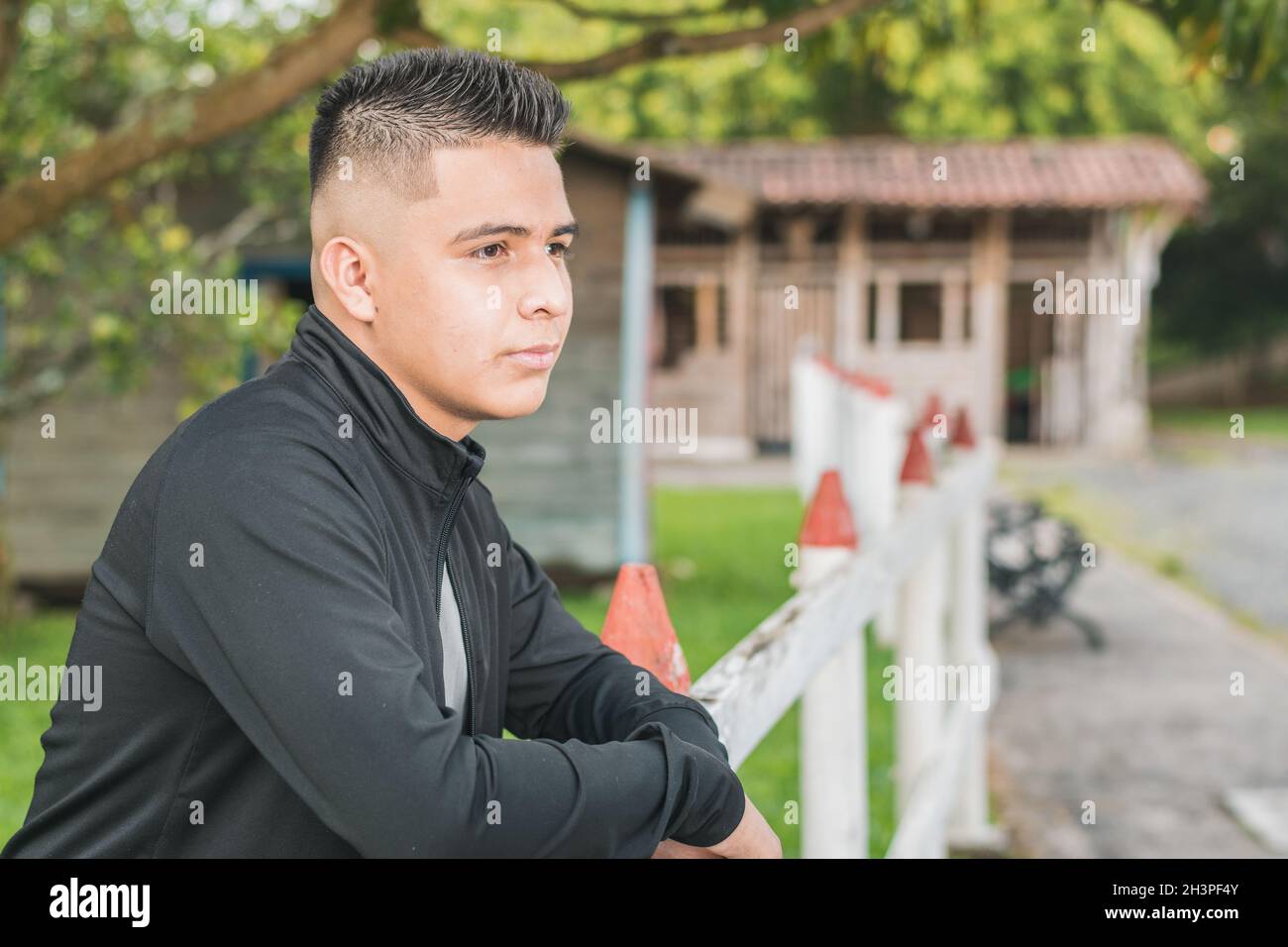 enterprising man standing by the white wooden fence, looking to the ...