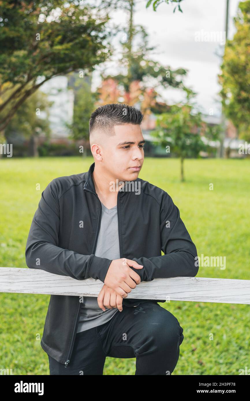 enterprising man standing by the white wooden fence with his hands on ...
