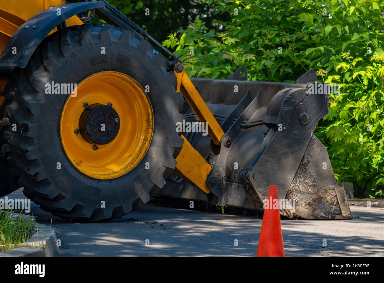 a view of a large wheel and bucket from a tractor, a yellow bulldozer ...
