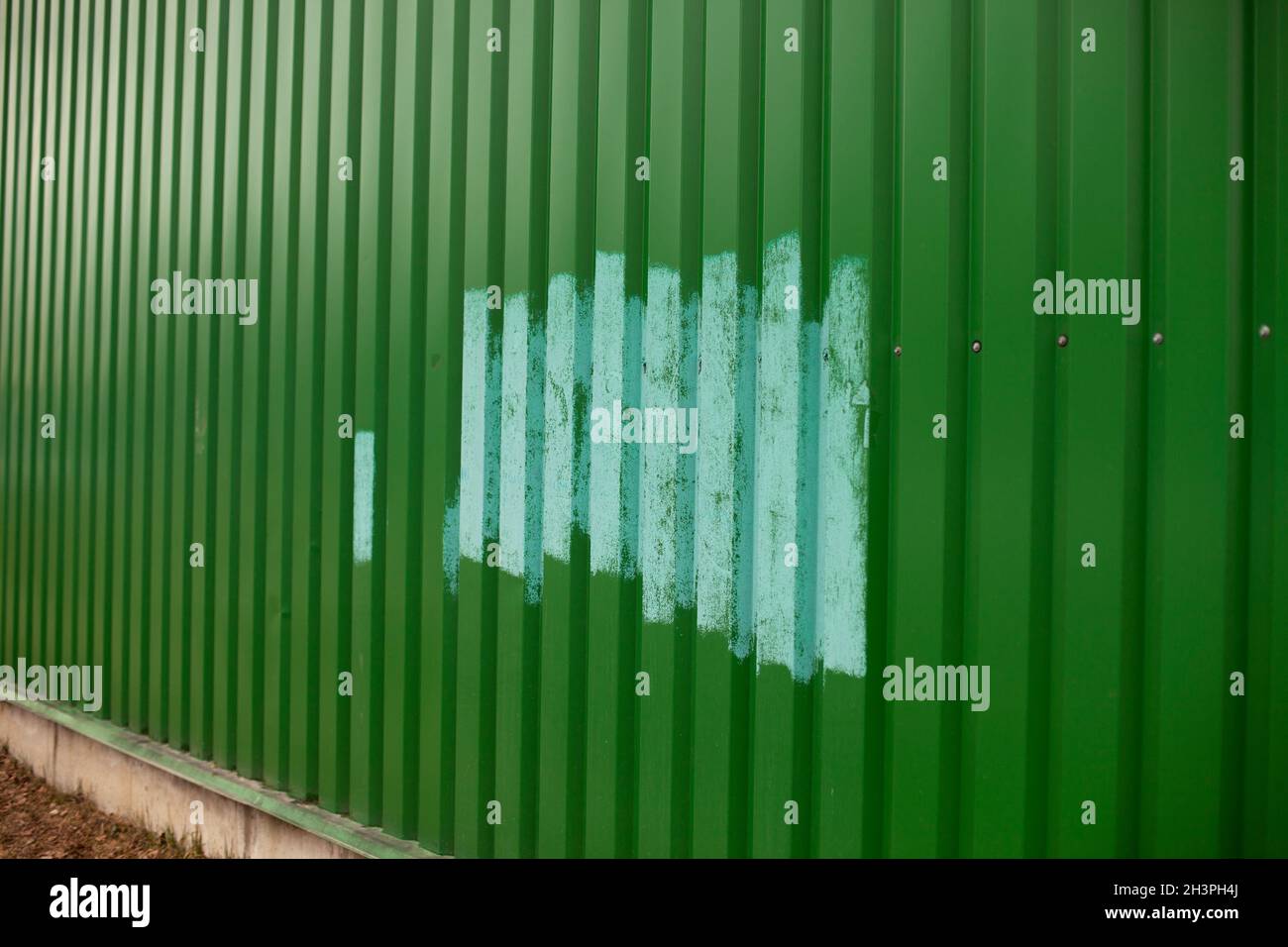 Fence painted after vandalism. Painting over graffiti on the fence ...