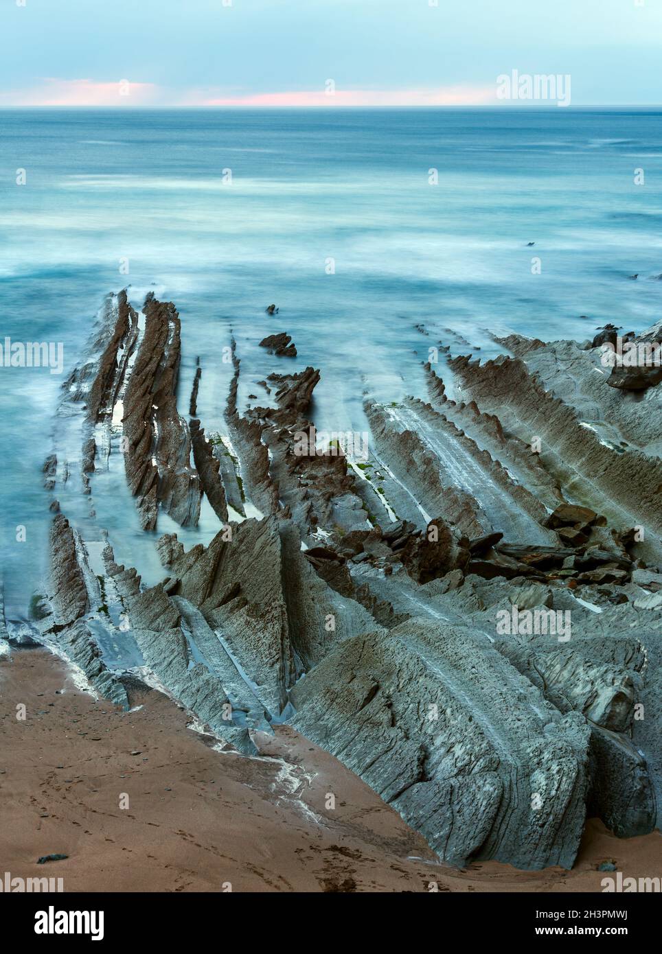Twilight ocean coast with ribbed stratiform rock formations. (Atlantic ...