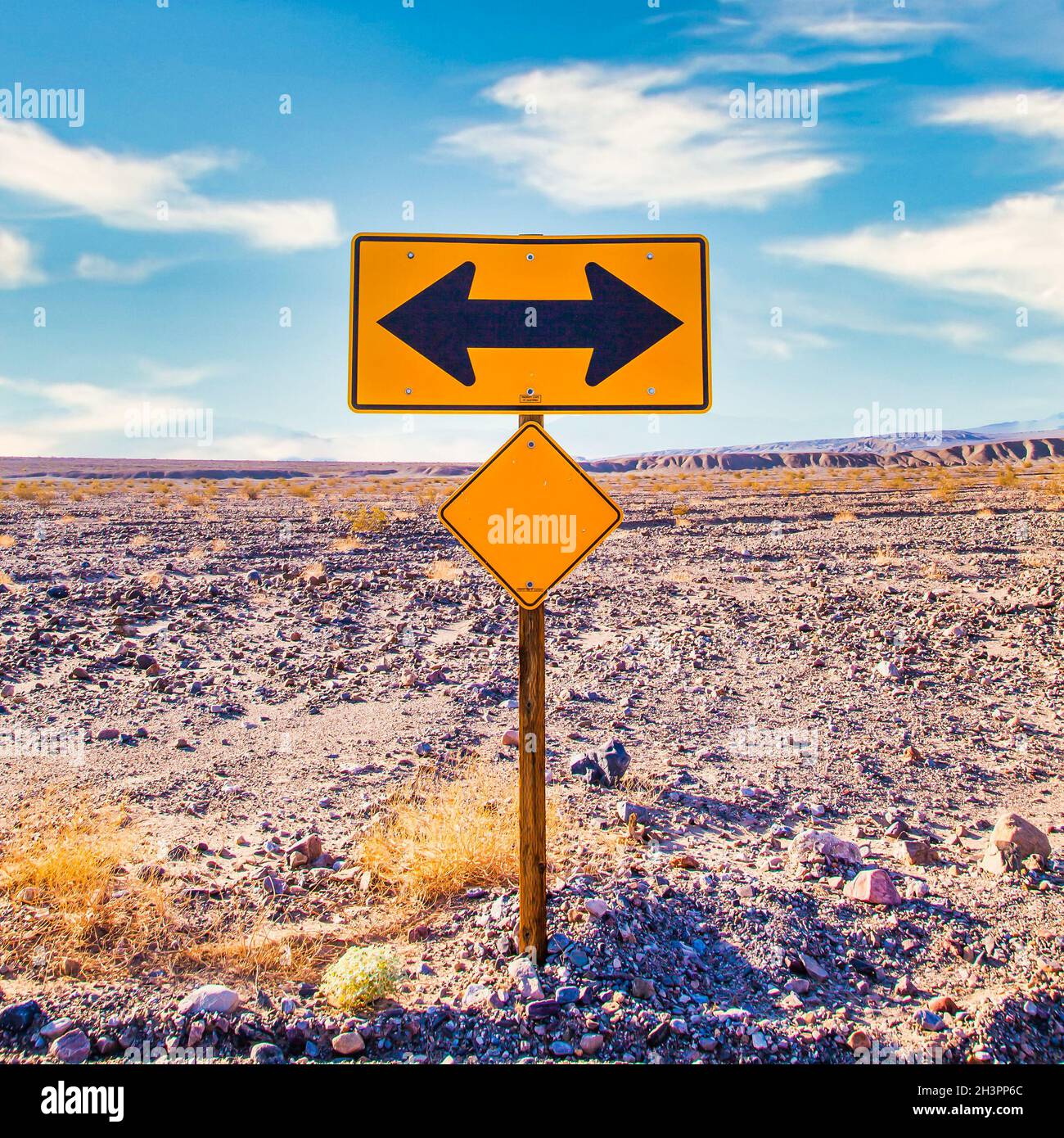 Directional sign in the desert with scenic blue sky and wide horizon ...
