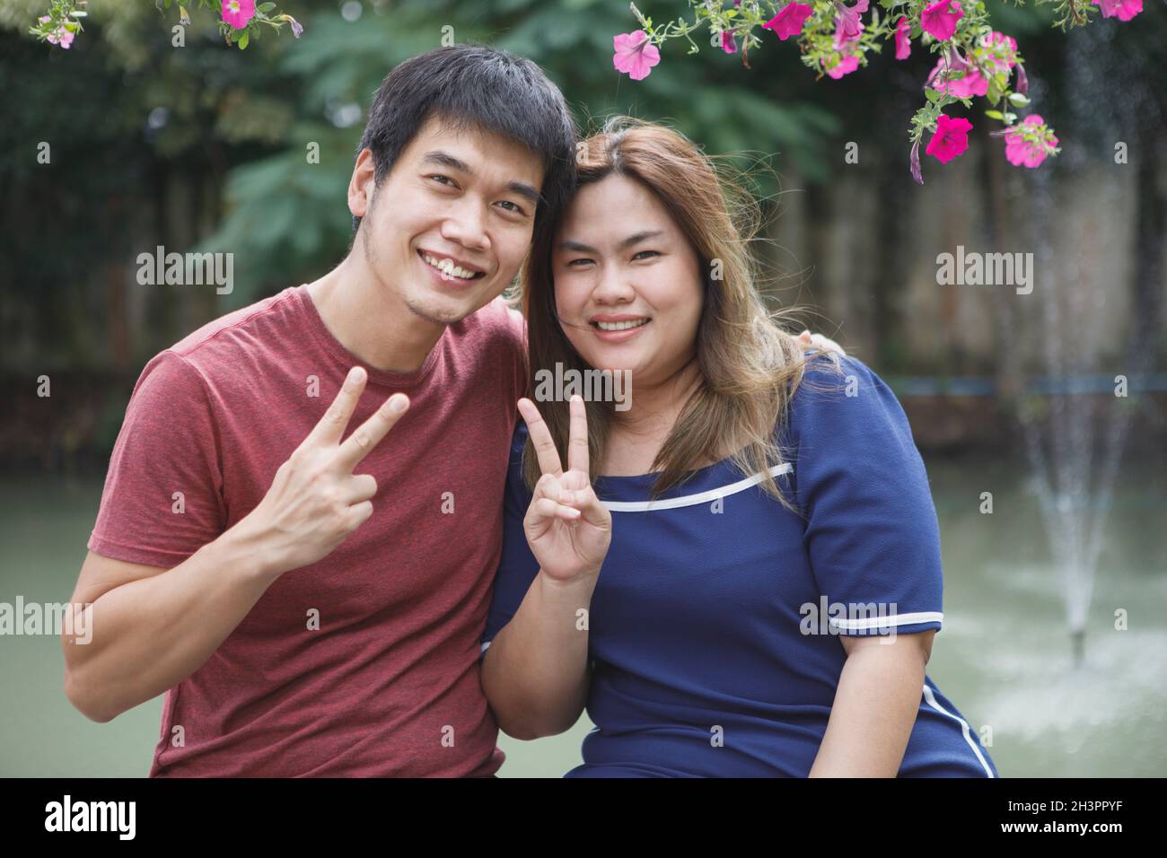 asian couples hand sign victory with happy smiling face Stock Photo - Alamy