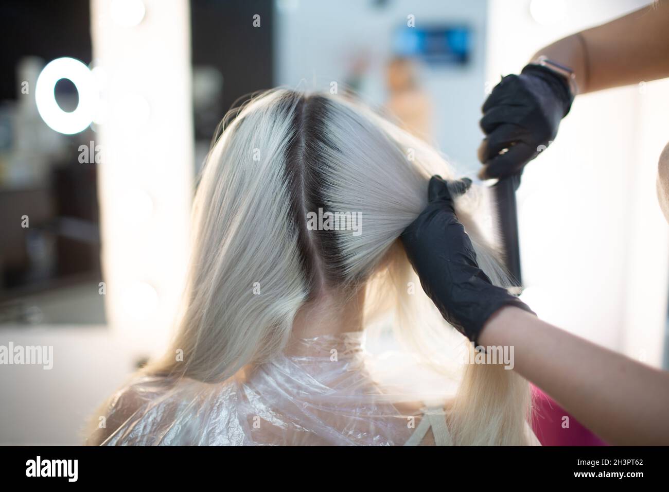 Young woman hairdresser dying unpainted hair at beauty salon ...